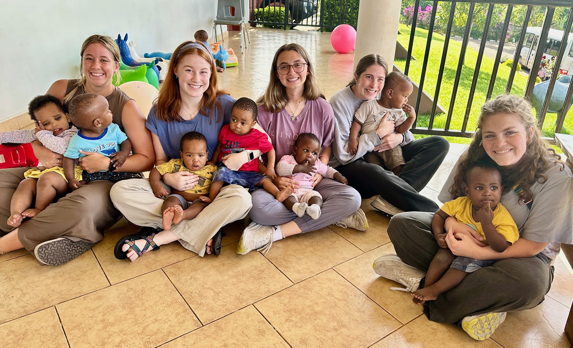 Volunteers holding babies – Neema Village